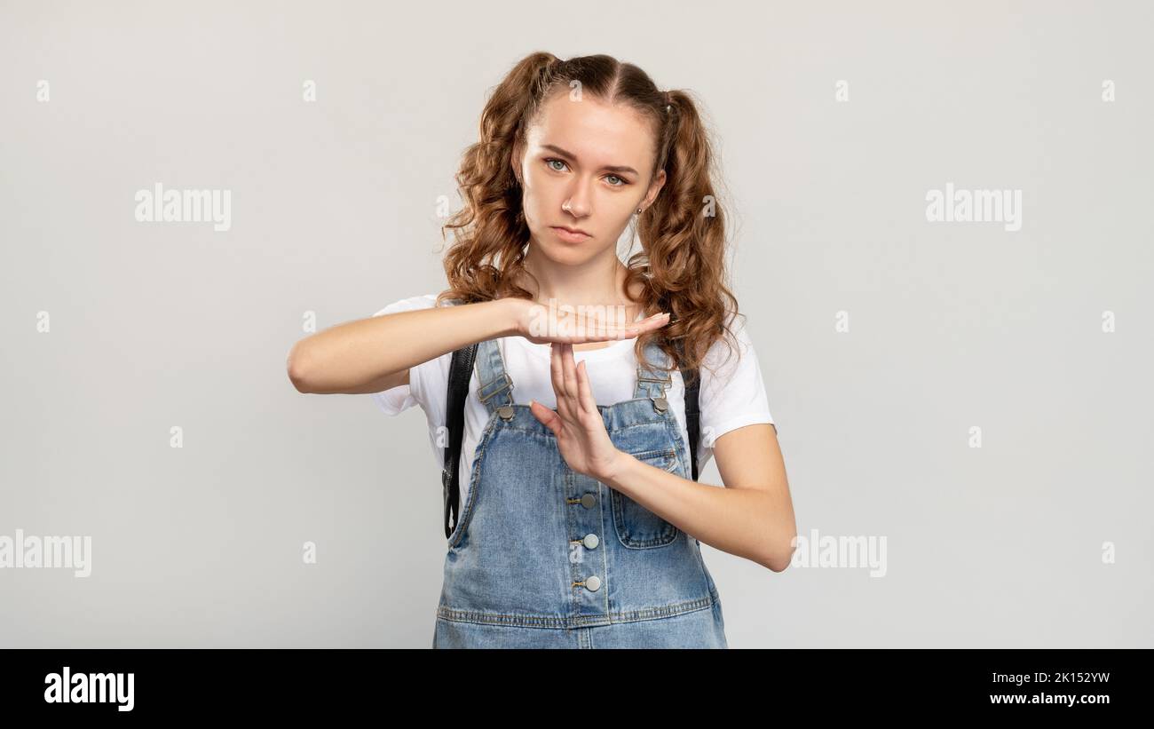 Time up. School protest. Confident student girl showing T gesture ...