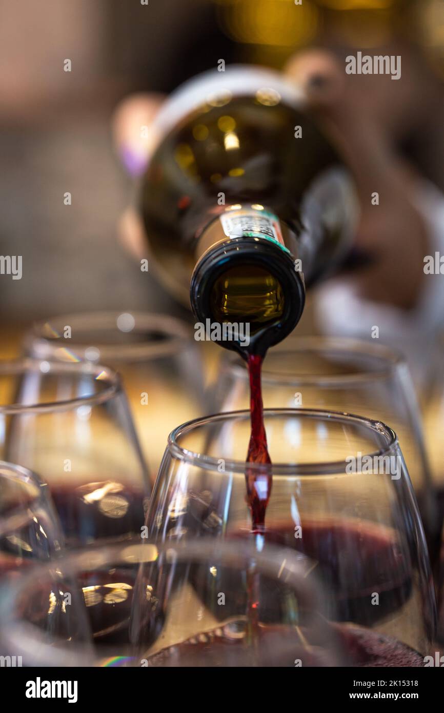 bottling red wine from a bottle by glasses close-up Stock Photo - Alamy