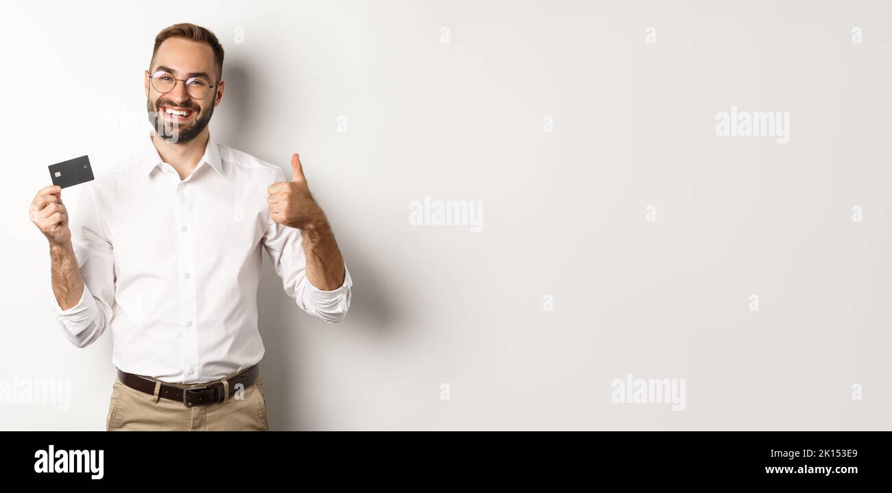 Handsome man showing his credit card and thumb up, recommending bank ...
