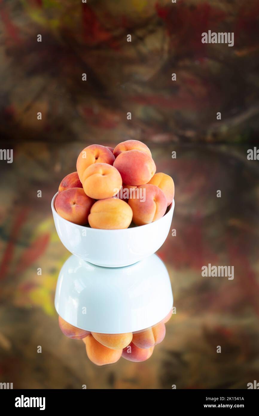 Classic food still-life of colourful Apricot fruit in a white bowl ...