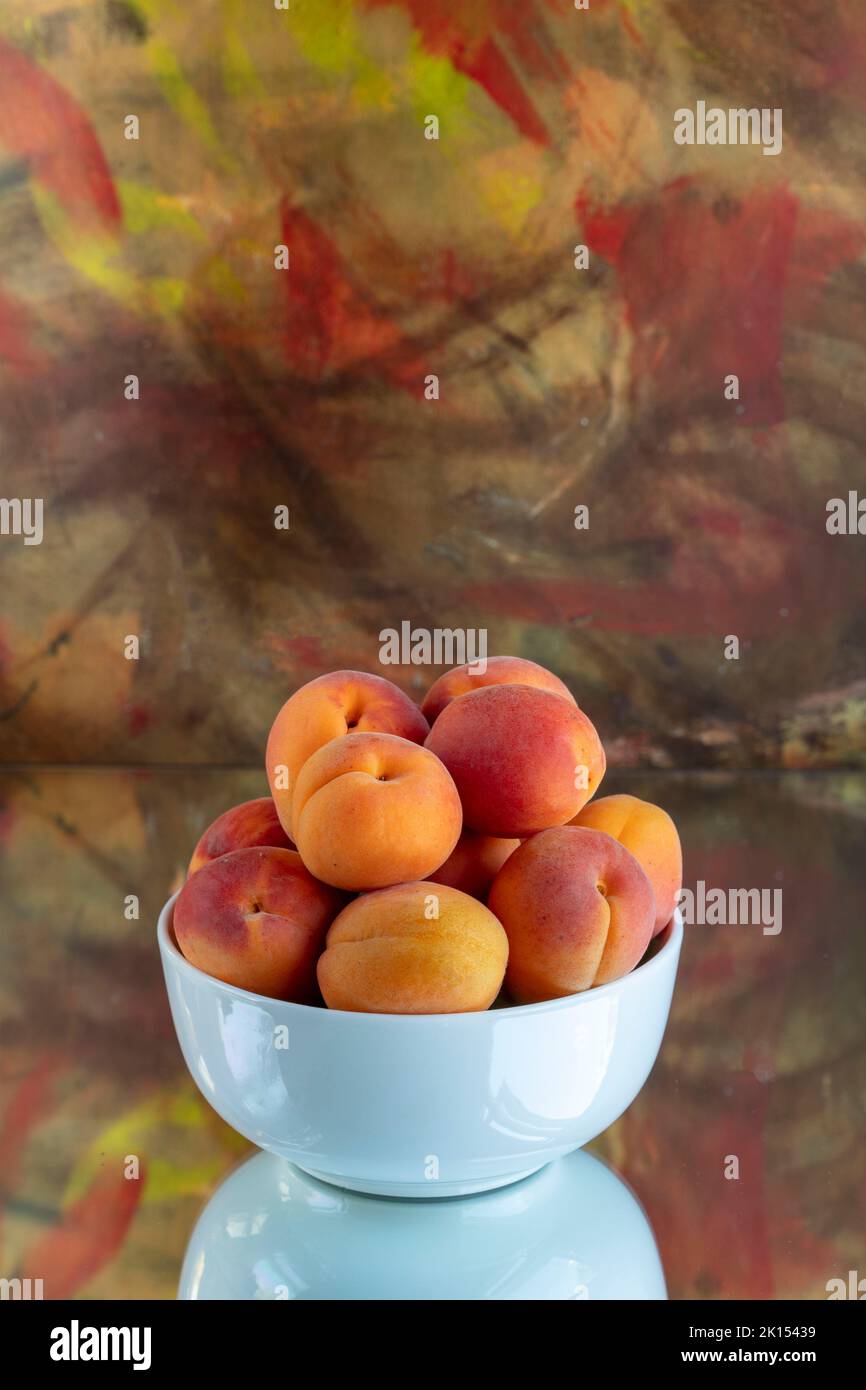 Classic food still-life of colourful Apricot fruit in a white bowl ...
