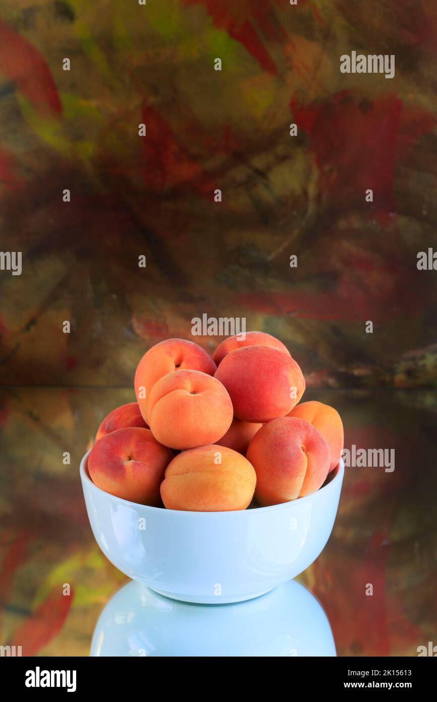 Classic food still-life of colourful Apricot fruit in a white bowl ...