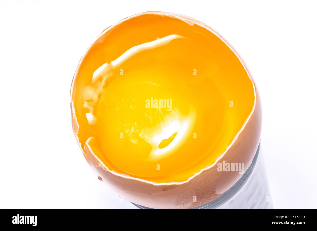 Egg yolk in a shell isolated on a white background. Egg yolk close-up ...