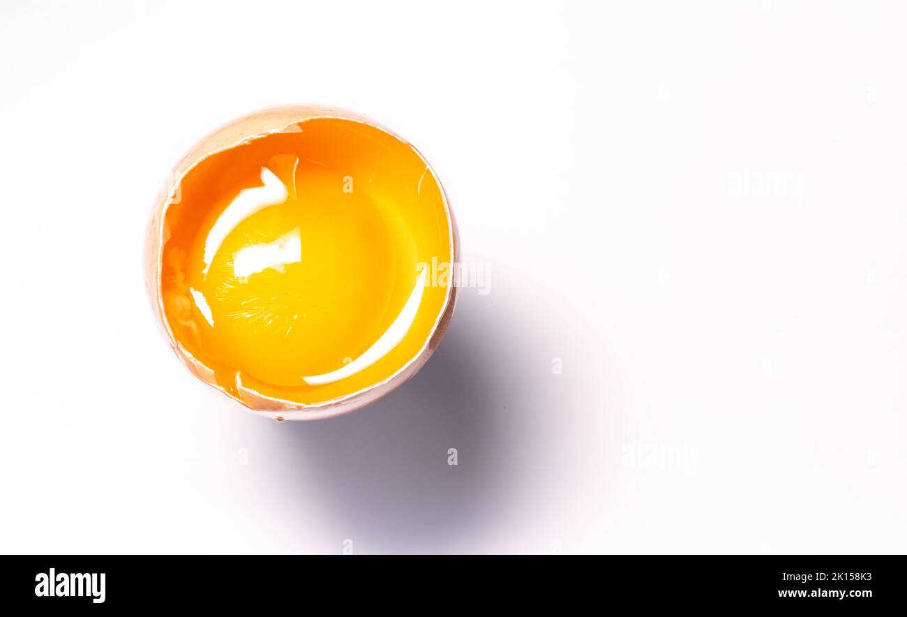 Egg yolk in a shell isolated on a white background. Egg yolk close-up ...