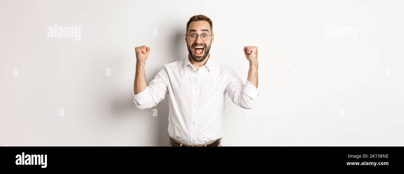 Successful businessman rejoicing, raising hands up and celebrating ...