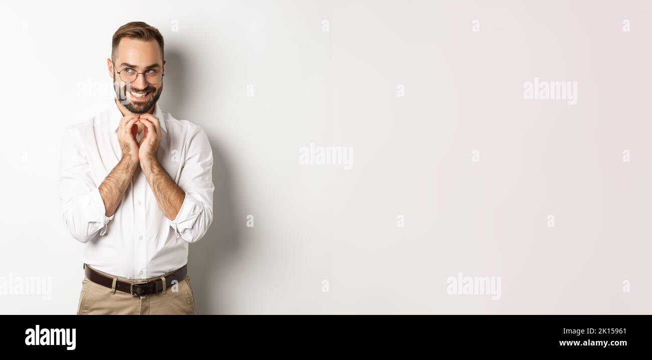 Young cunning businessman steeple fingers and smiling devious, scheming ...