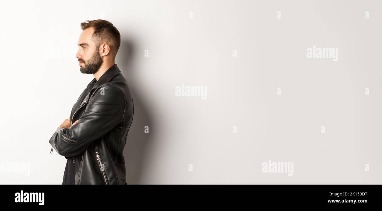 Profile of handsome serious man in leather jacket, looking left ...