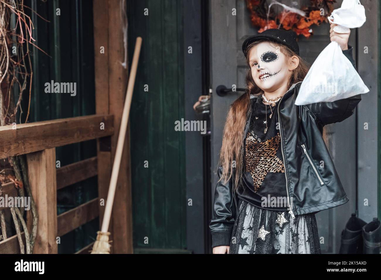Scary girl celebrating halloween. Playing treak or treat game on porch ...