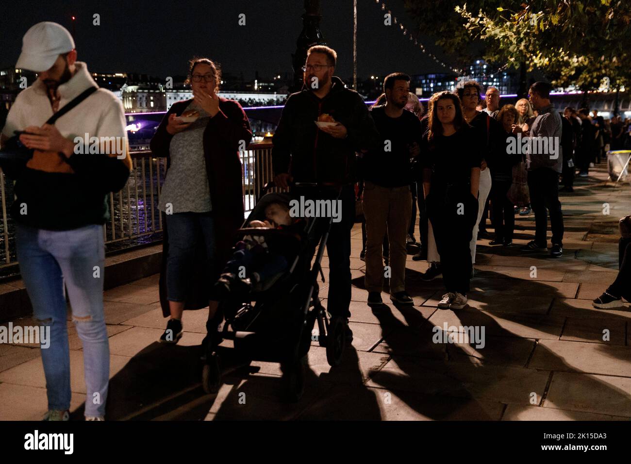 A couple holds burgers queuing at Southbank as members of the public ...