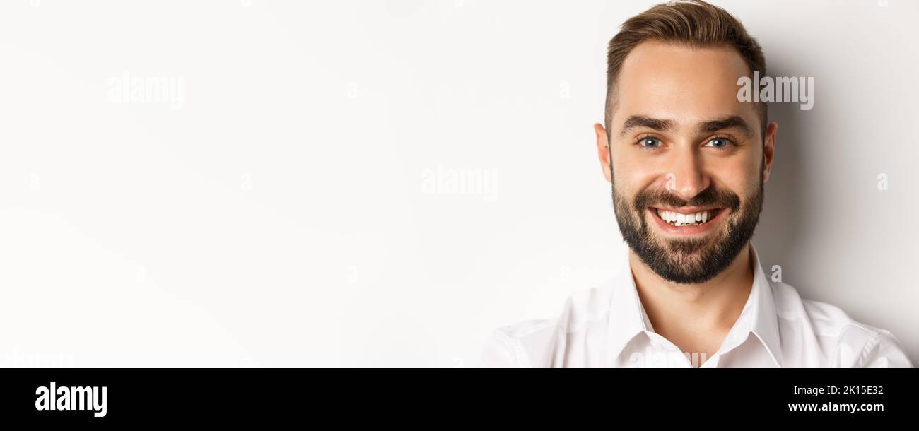 Headshot of handsome bearded man smiling, standing against white ...