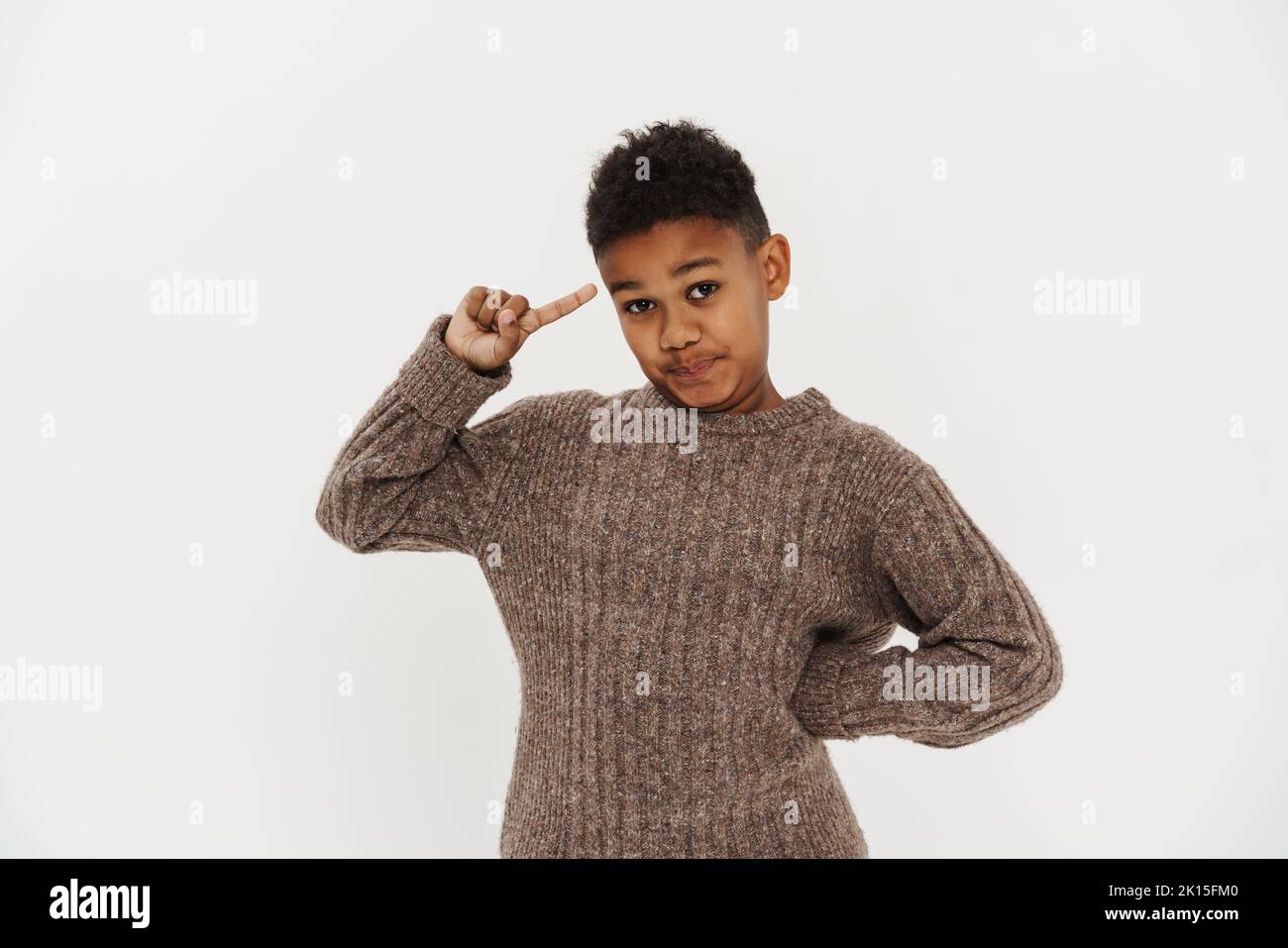 Black preteen boy pointing finger at his temple and grimacing isolated ...