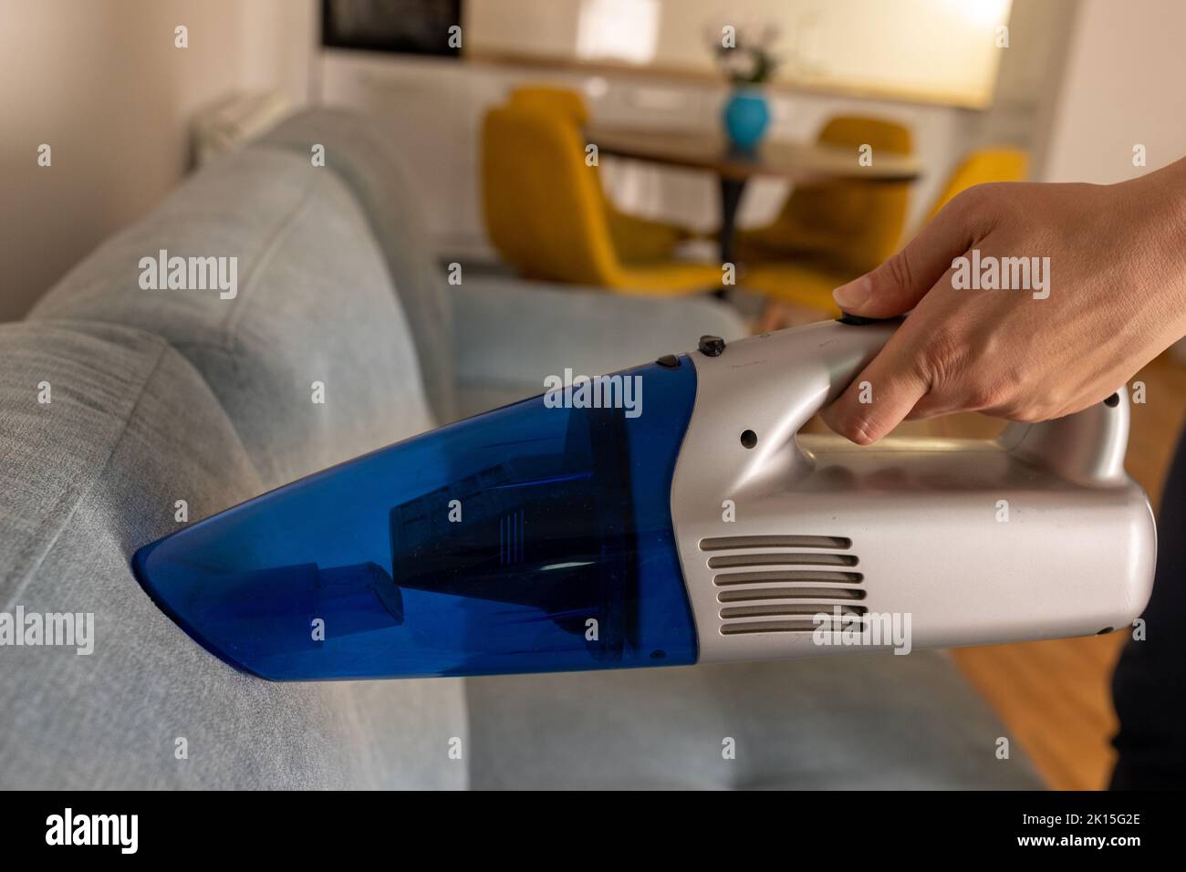 Close up of female hand holding rechargeable wireless vacuum cleaner ...