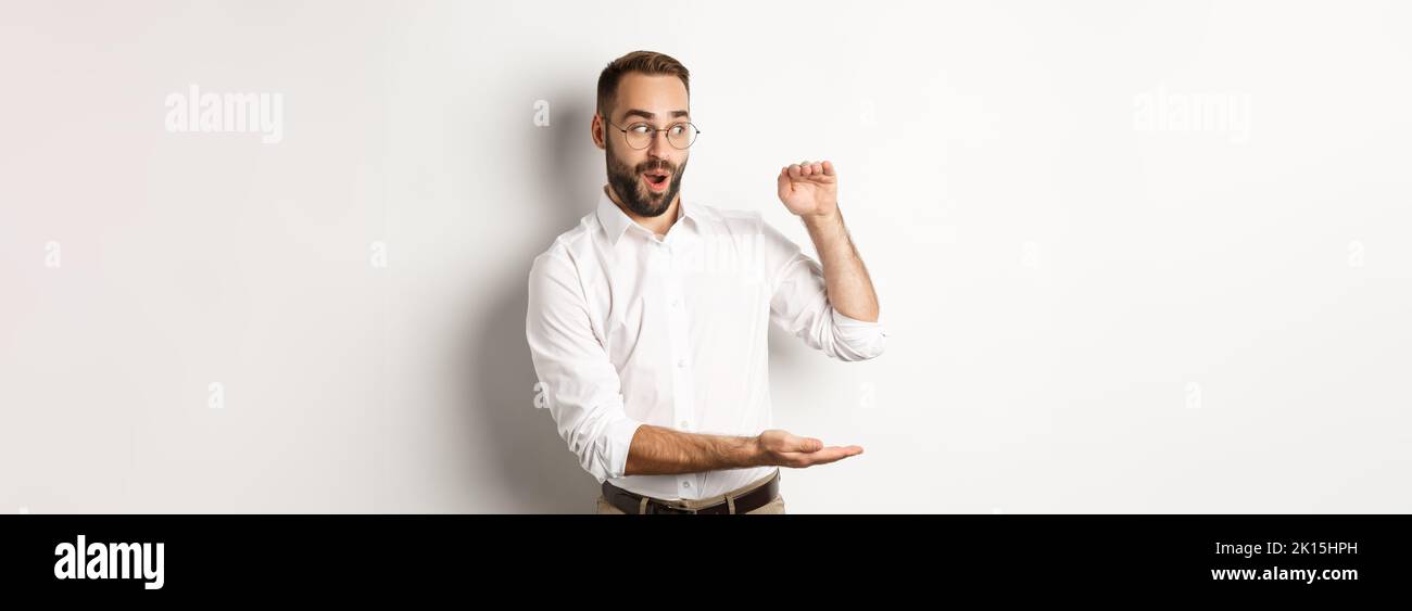 Amazed businessman showing big object, describe something large and ...