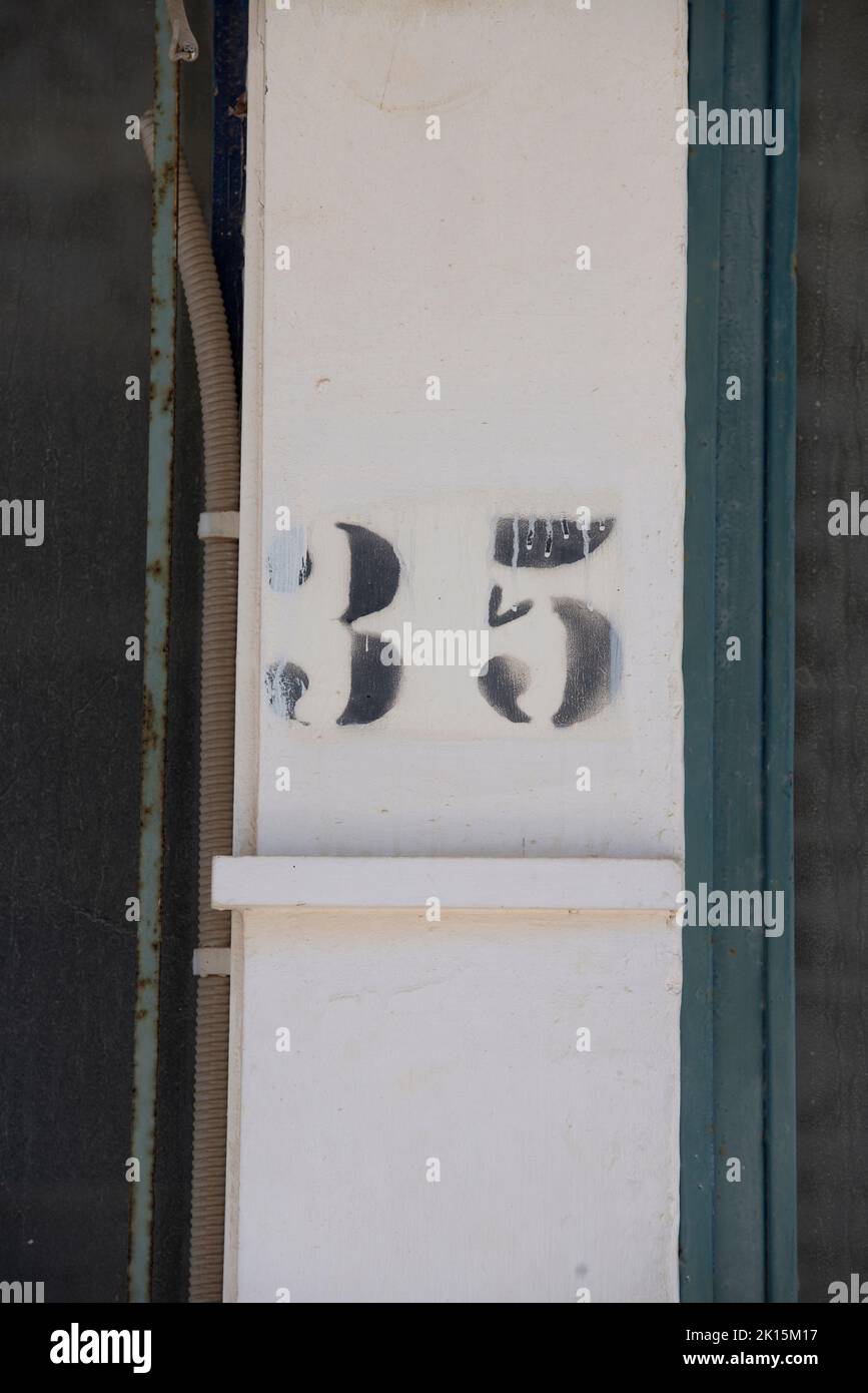 A vertical shot of a painted house number '35' on a pillar Stock Photo ...