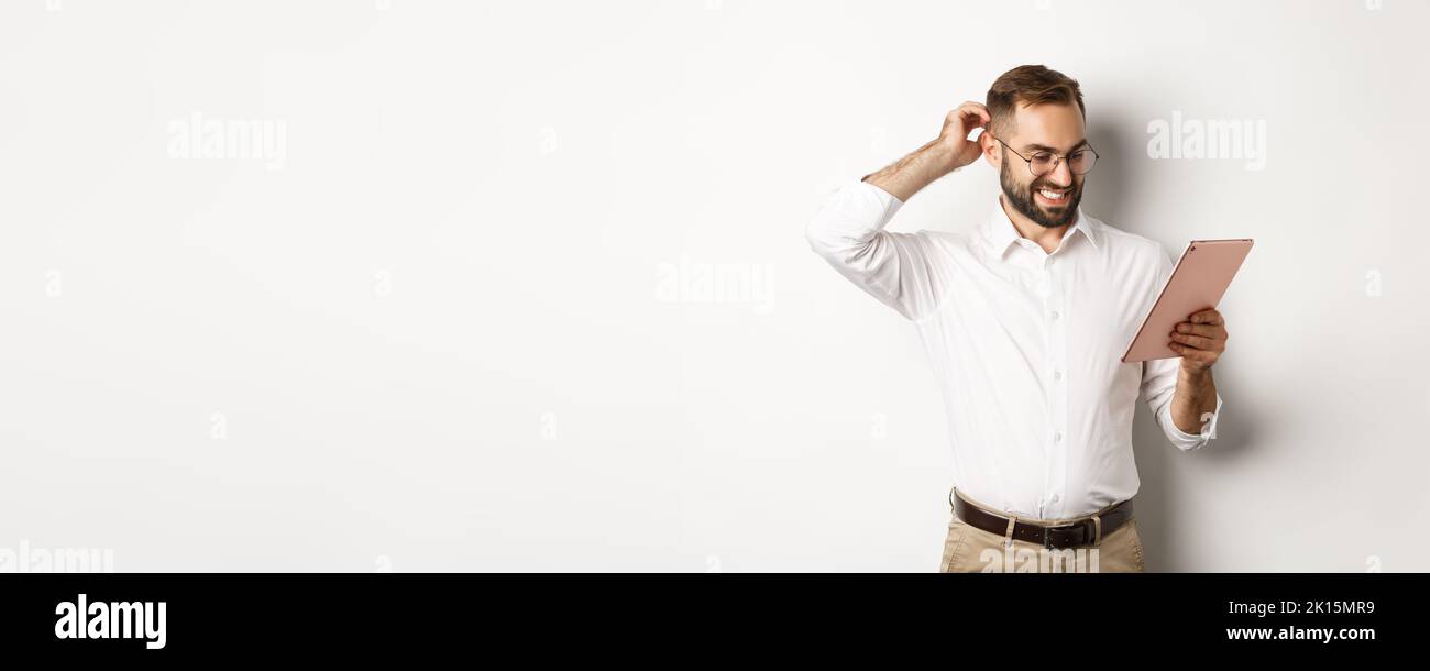 Confused male manager looking puzzled at digital tablet, scratching ...