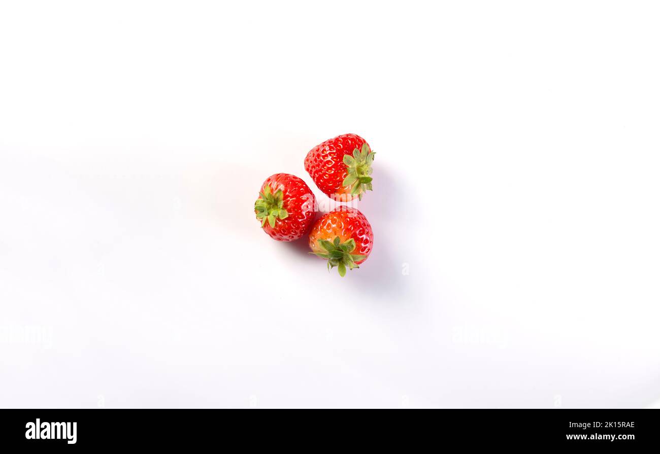 3 Strawberries centered on a white surface, studio light used Stock ...