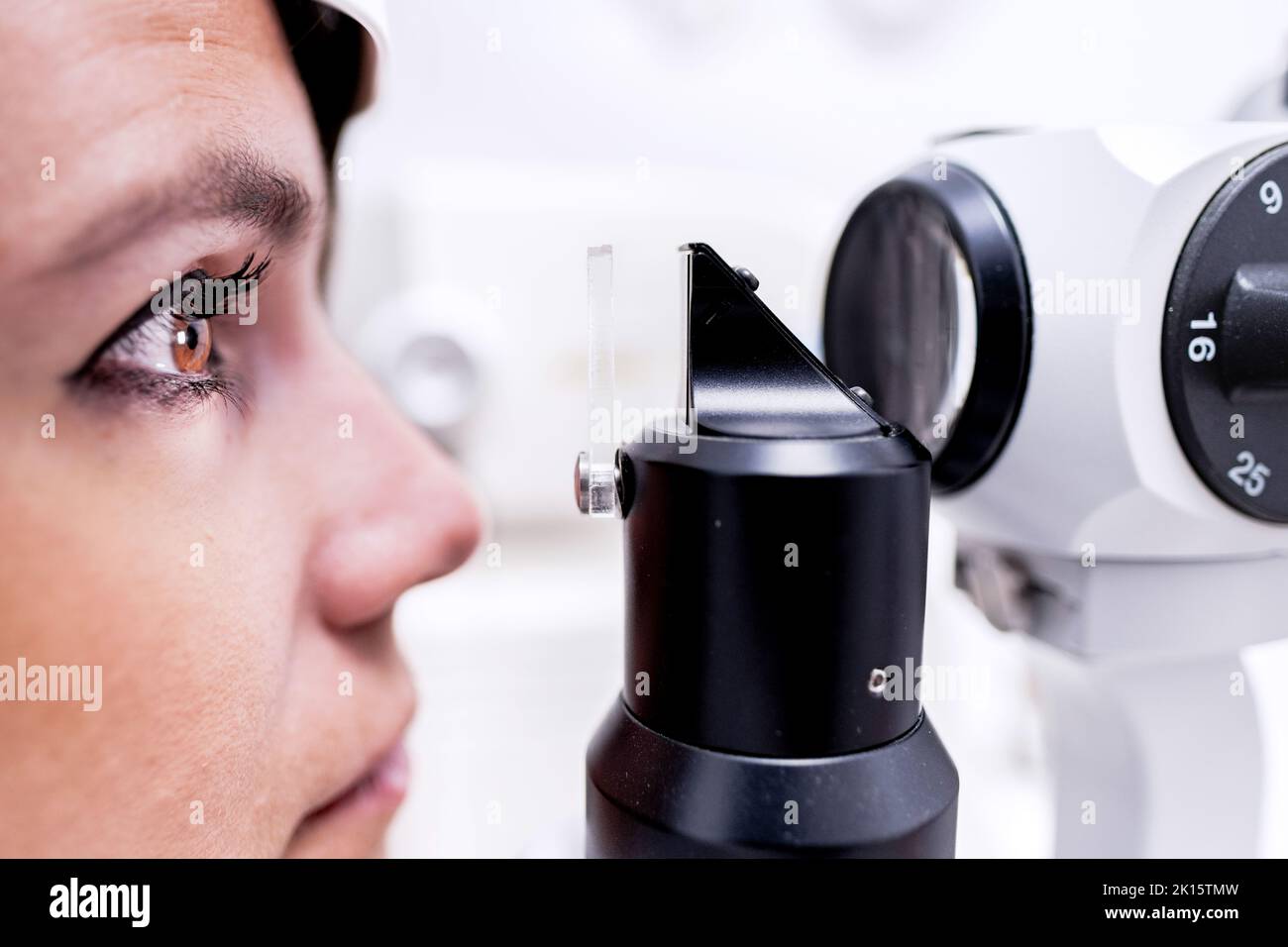Closeup female patient with eye illuminated with light waiting for ...
