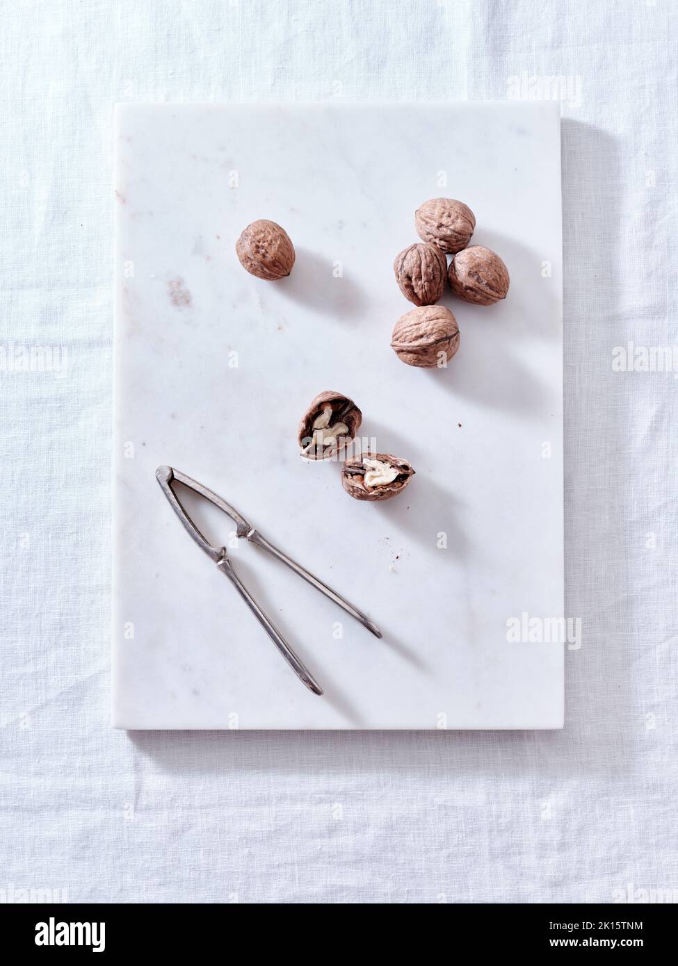 Opening walnuts with a cracker top view. White background Stock Photo ...