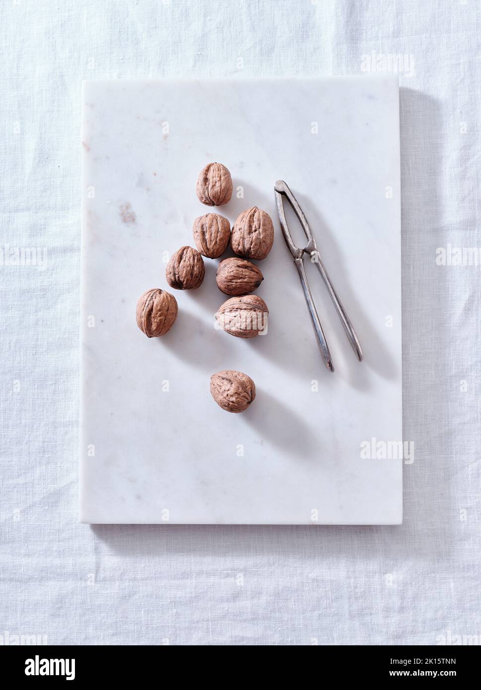 Opening walnuts with a cracker top view. White background Stock Photo ...