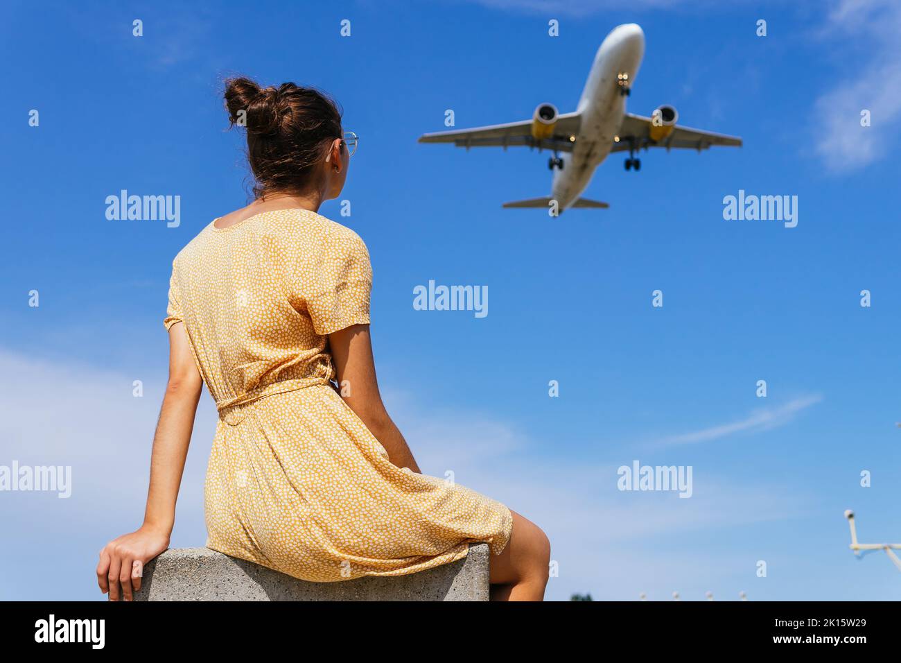 From below back view of unrecognizable female in casual clothes sitting ...