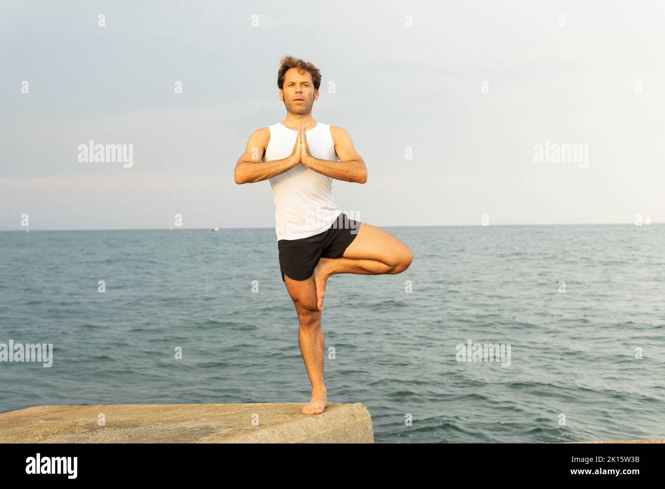 Full body middle aged man in activewear looking away and balancing in ...