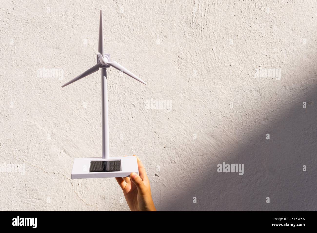 Crop unrecognizable person demonstrating small solar powered wind ...