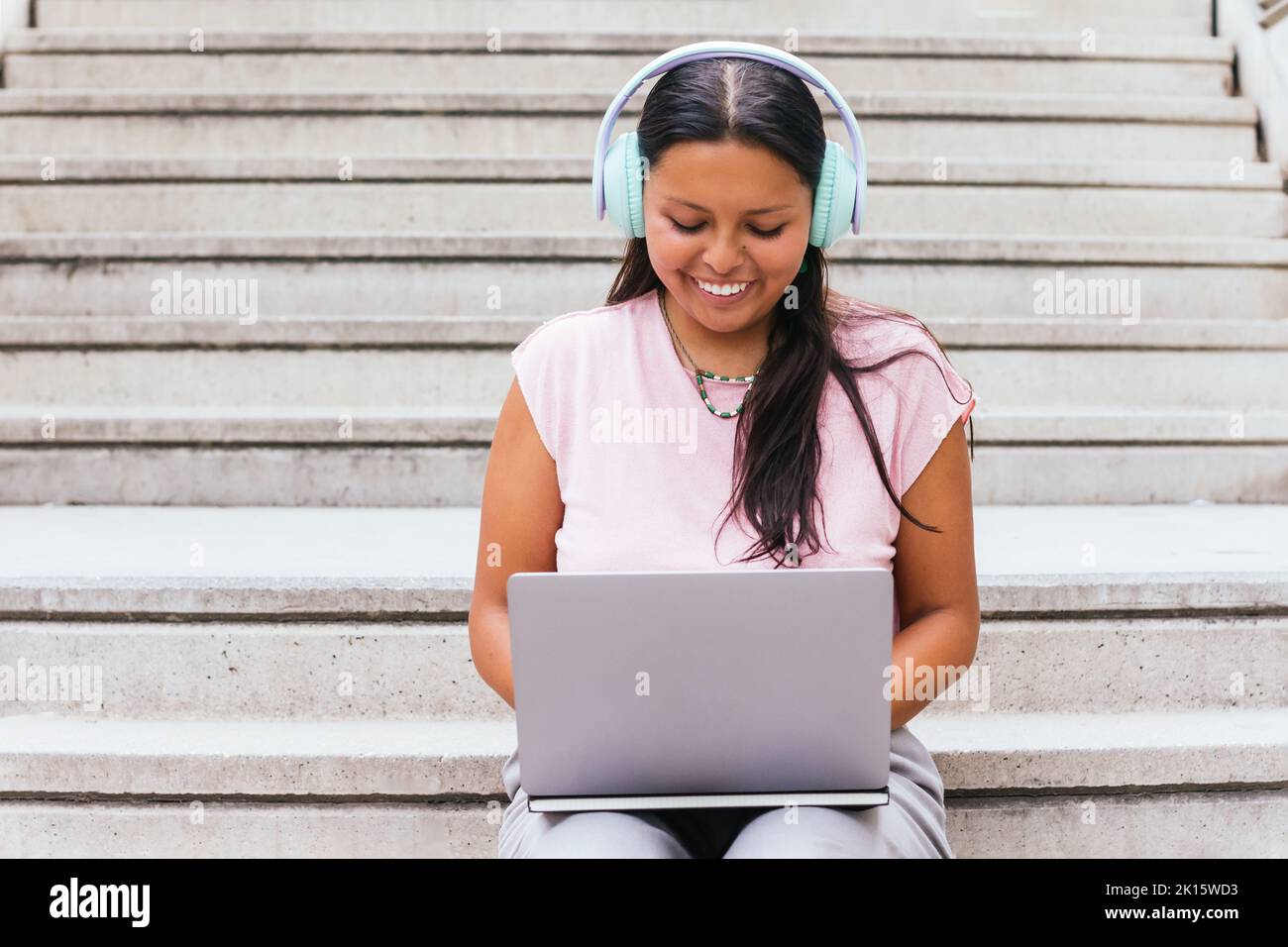 Positive young ethnic self employed woman with long dark hair in casual ...