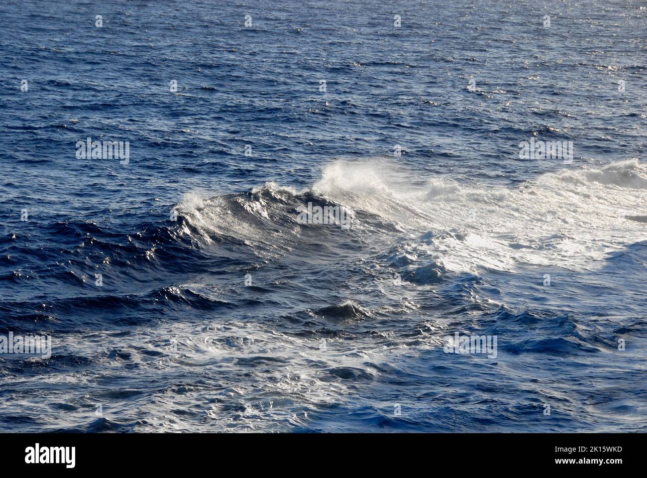 Wave breaking on calm sea near passing cruise liner, Caribbean Stock ...