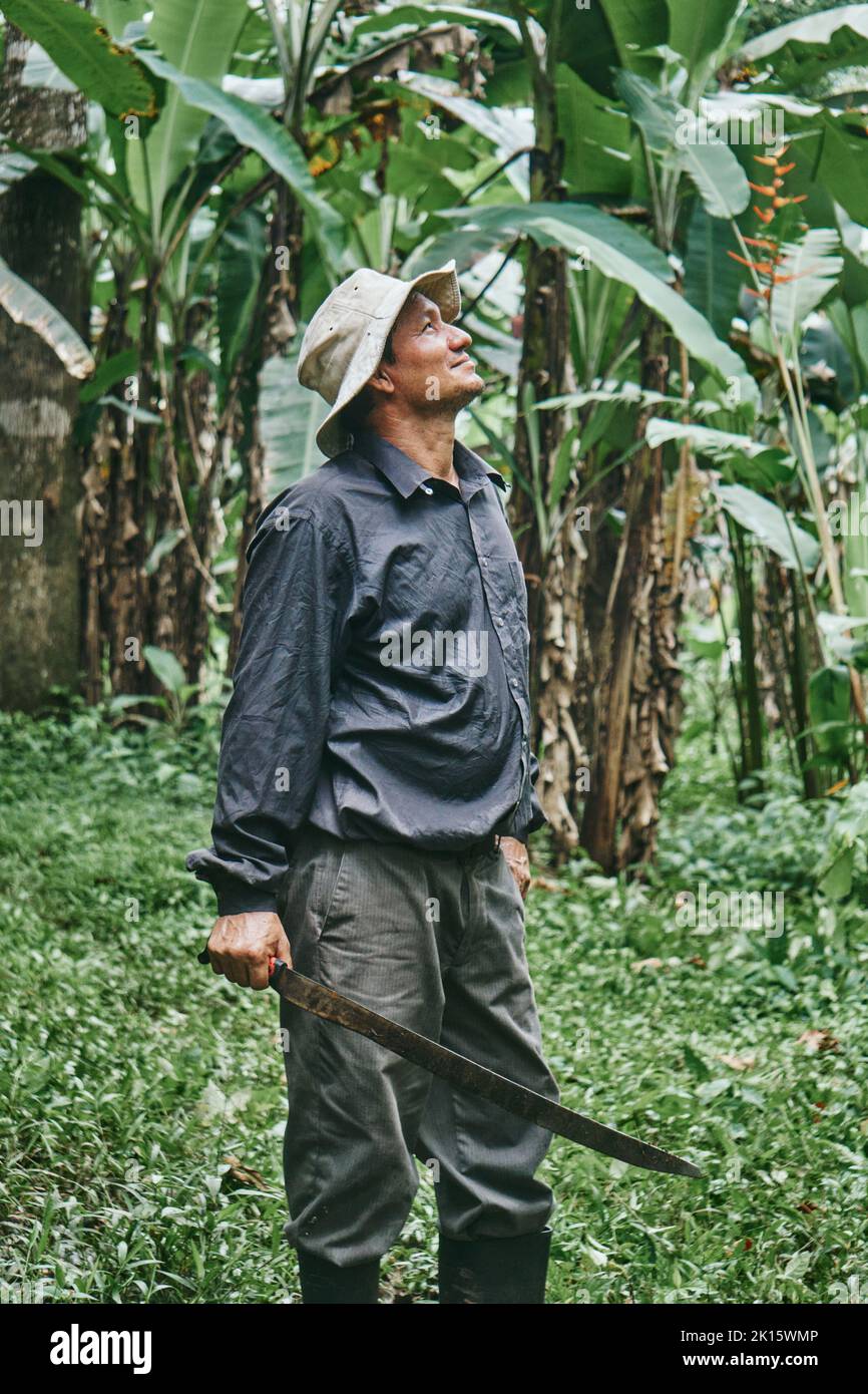 Side view of positive Hispanic man in shirt and bucket hat walking with ...