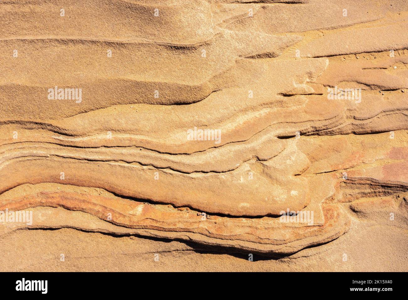 Rough textured surface of sandstone cliff with cracks and uneven lines ...