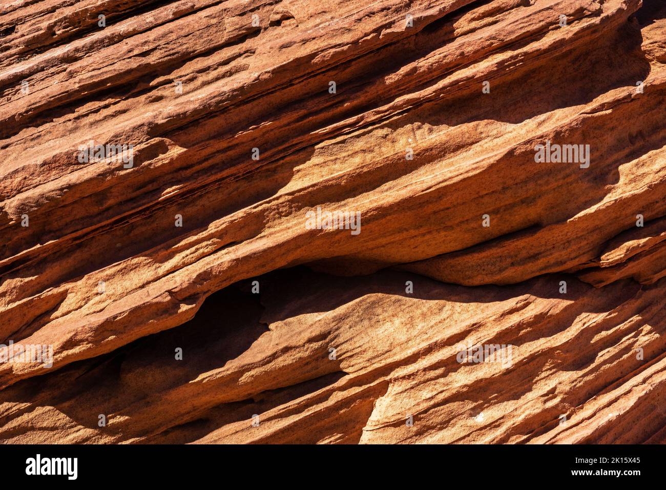 Rough textured surface of sandstone cliff with cracks and uneven lines ...