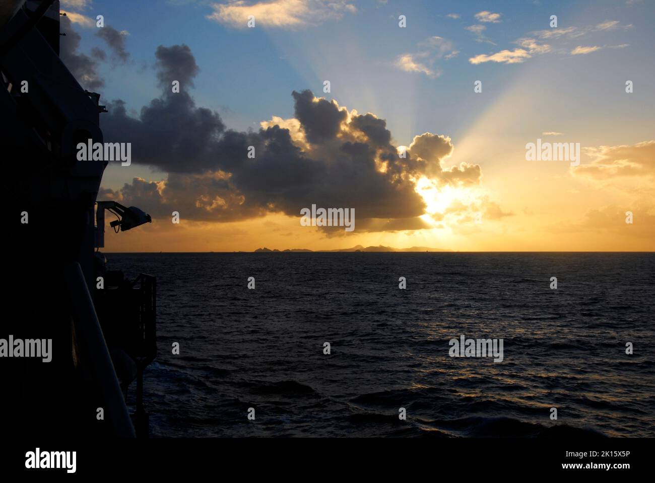 Spectacular sunset at sea, Caribbean, with the sun's rays coming from ...