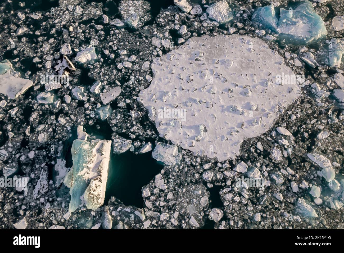 Aerial top view of snowy ice floes floating on surface of cold sea ...