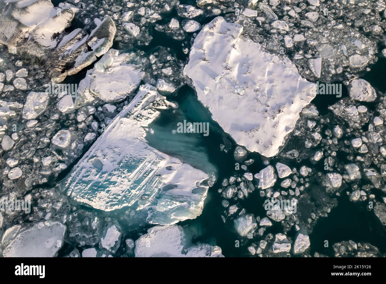 Aerial top view of snowy ice floes floating on surface of cold sea ...