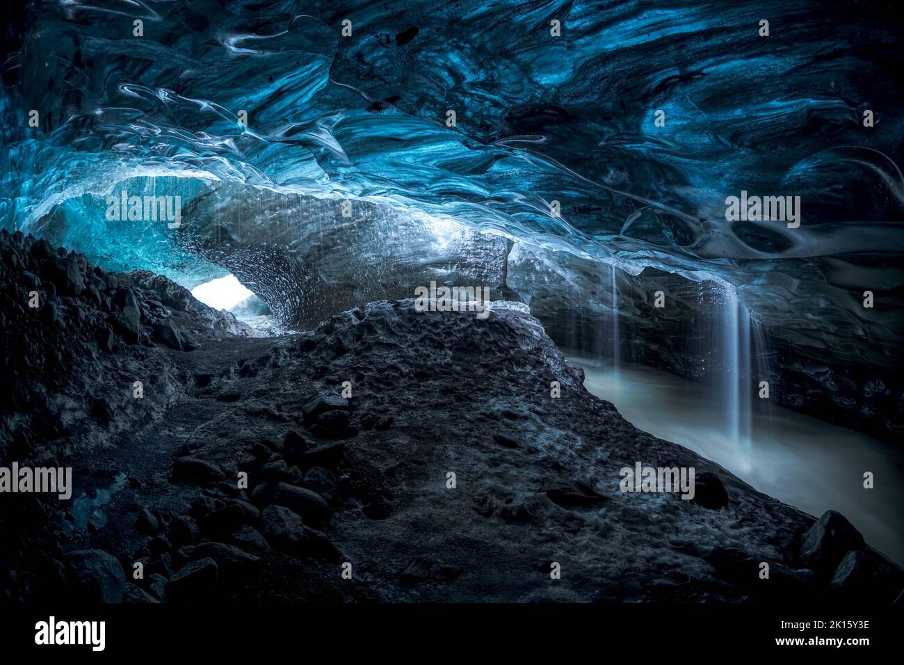 Skaftafell ice cave with rough blue walls and brook on cold winter day ...