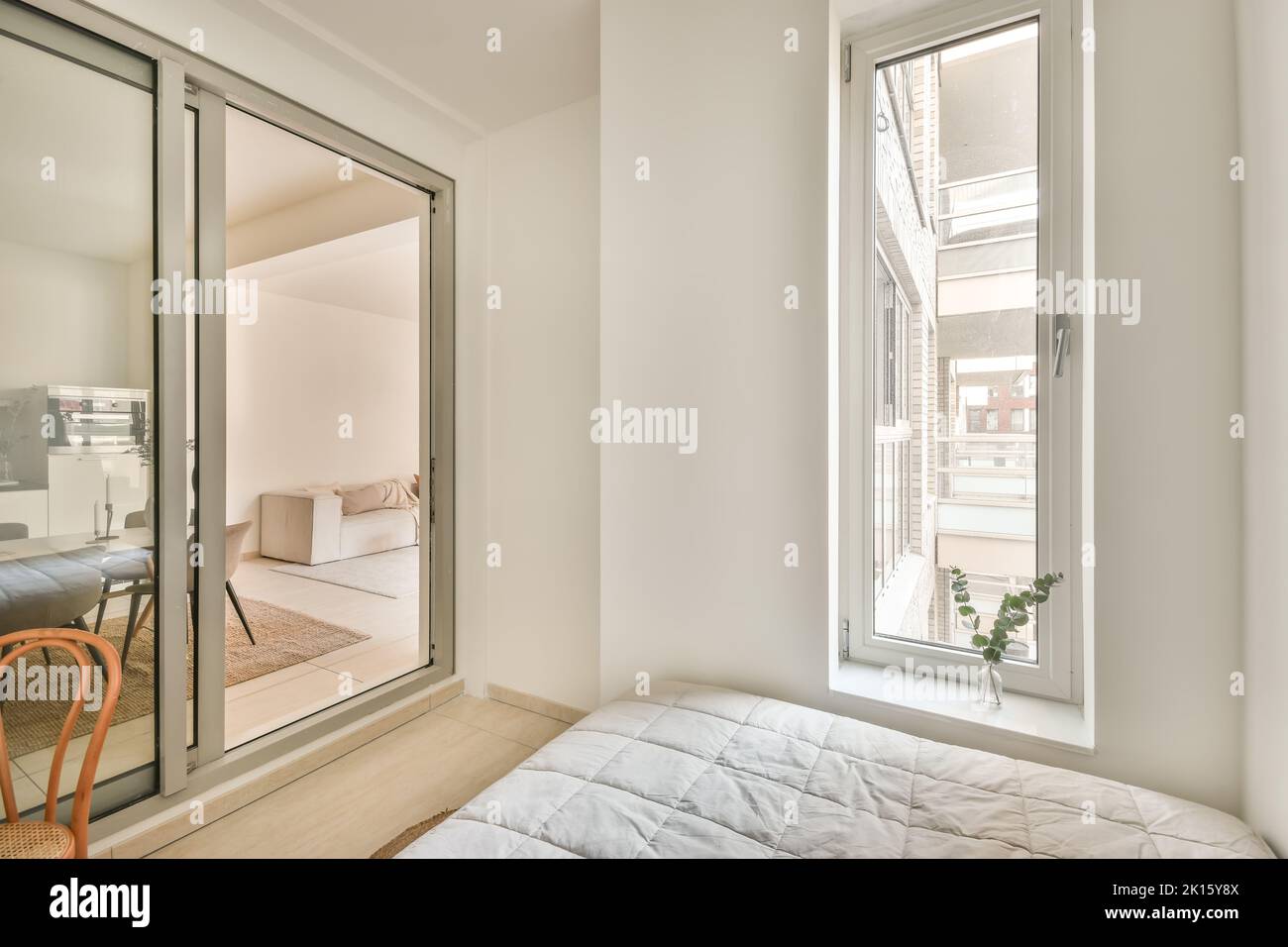 Comfortable bed with white walls next to a window Stock Photo - Alamy