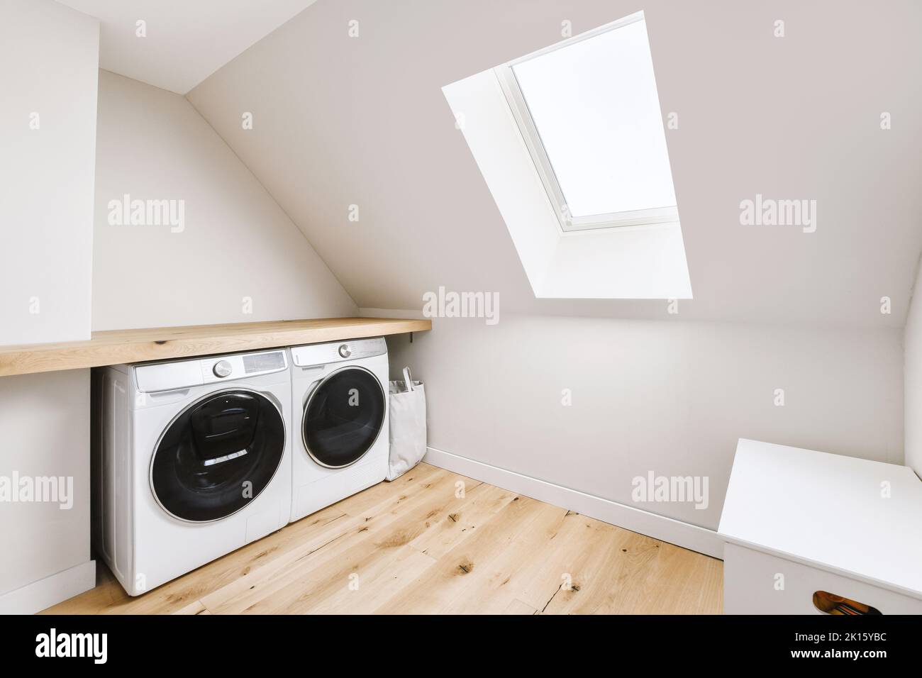 Modern washing and dryer machines placed in light bathroom with white ...