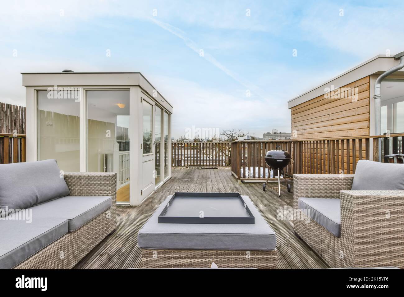wooden terrace in roof top of a modern house building with table and ...