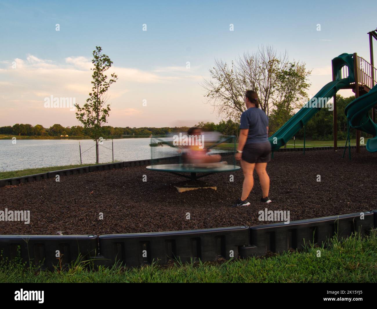Woman Spinning Children on Merry Go Round in Spring Hill Kansas Stock ...
