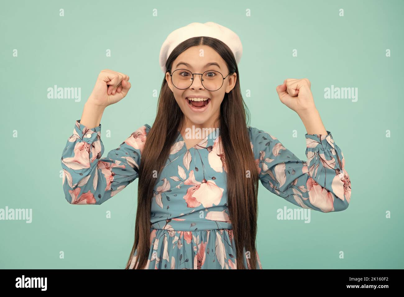 Studio portrait of teenager child doing winner gesture. Kid rejoicing ...