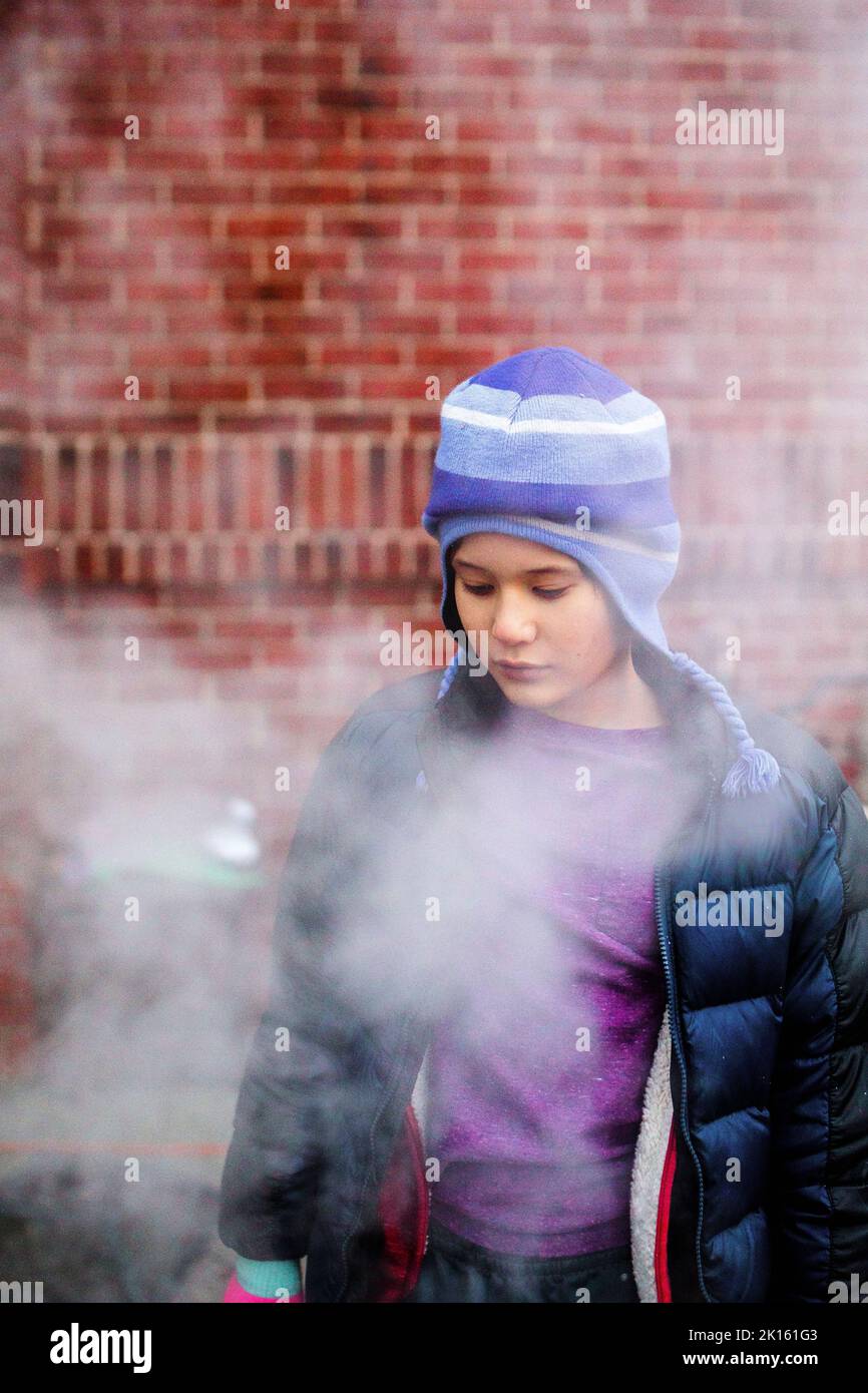 A beautiful serious child standing in smoke gazes down Stock Photo - Alamy
