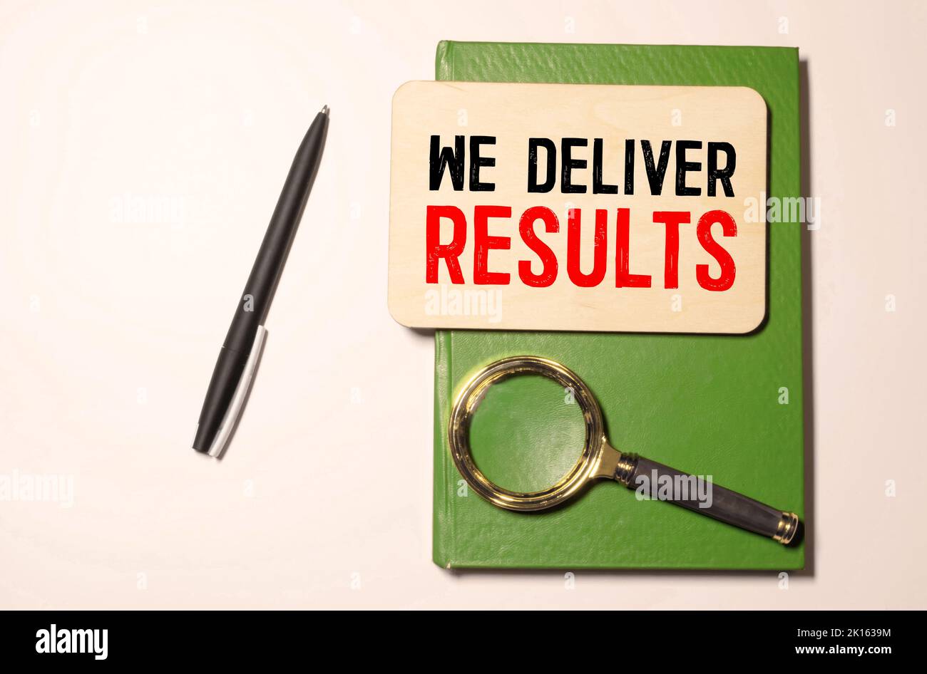 Business concept. Notebook with text WE DELIVER RESULTS sheet of white ...