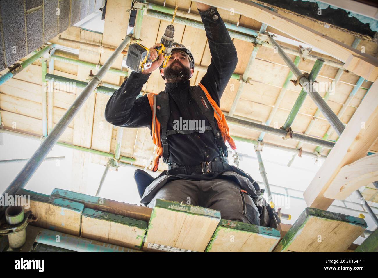 A carpenter / joiner working on scaffoldong at a building site in ...