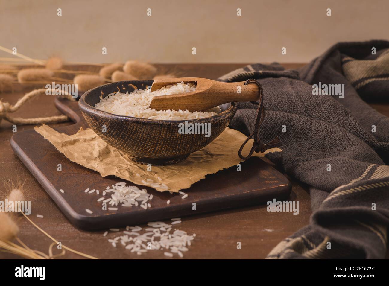 Basmati rice in ceramic bowl with wooden scoop on rustic countertop ...