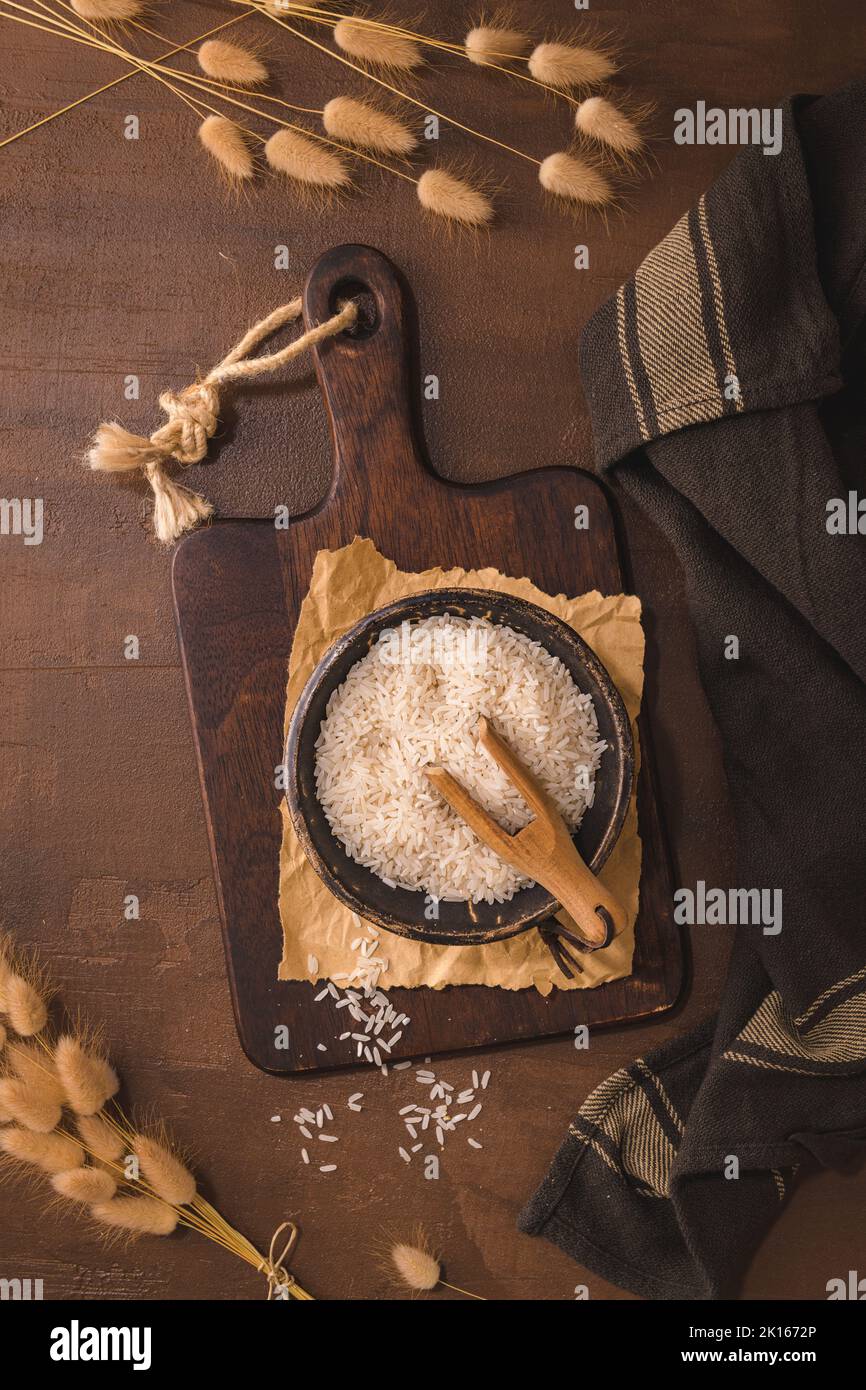 Basmati rice in ceramic bowl with wooden scoop on rustic countertop ...