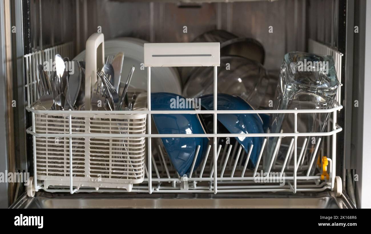 Dishwasher with dishes .Appliances for the kitchen. Plates, forks and ...