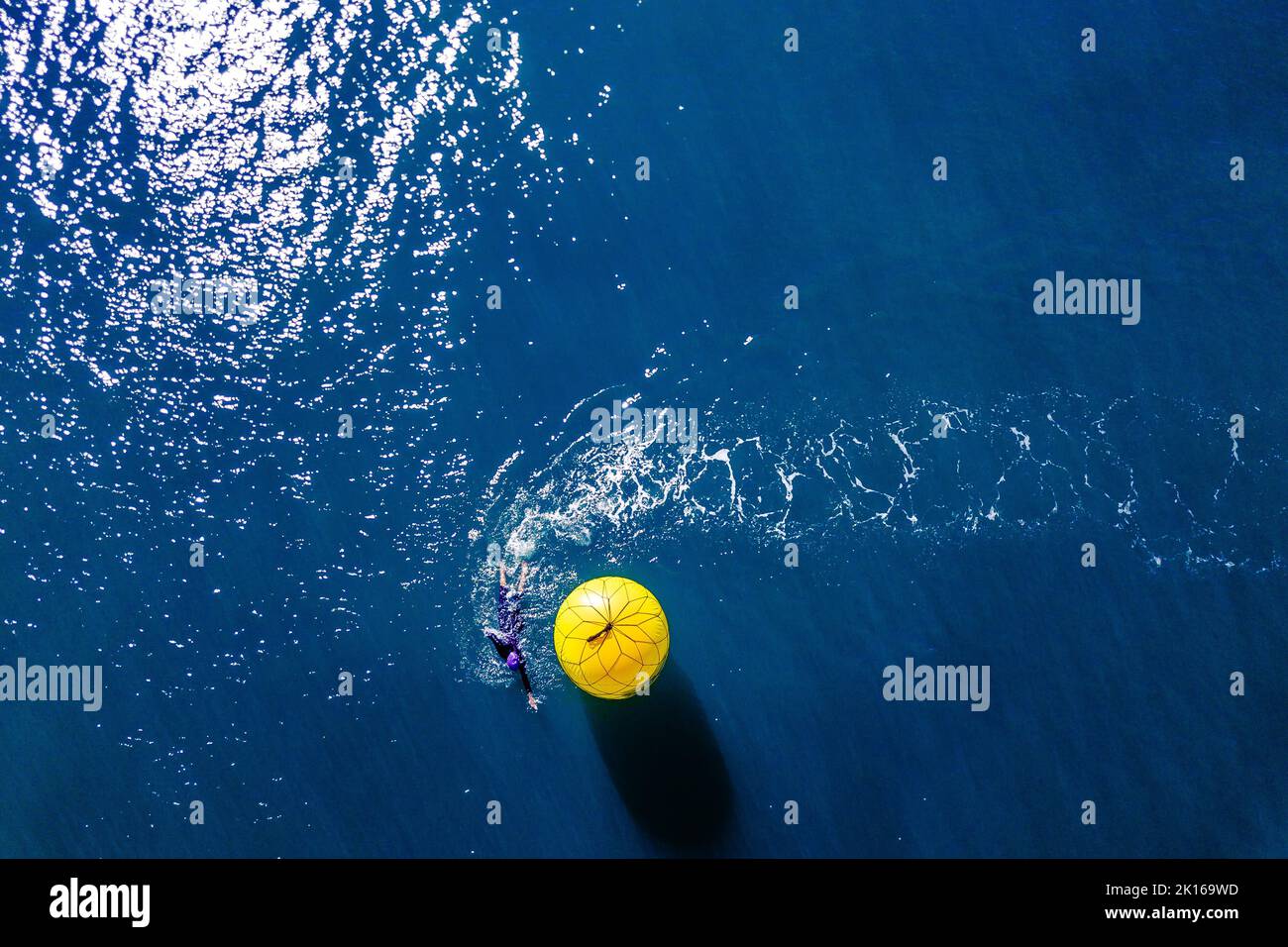 Swimmer swimming around a Buoy in the Ocean Stock Photo - Alamy