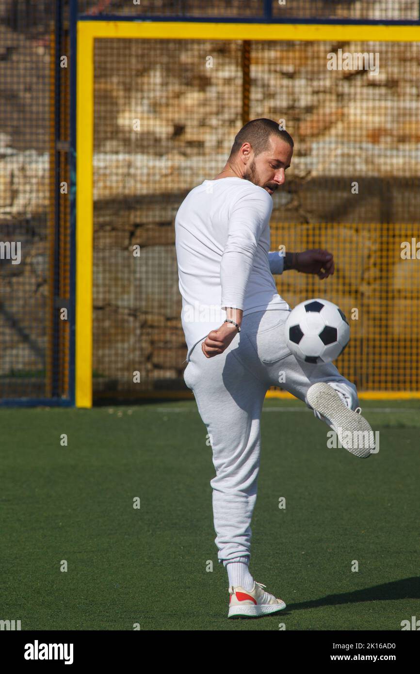 Young male soccer player juggles a ball on a soccer field Stock Photo ...