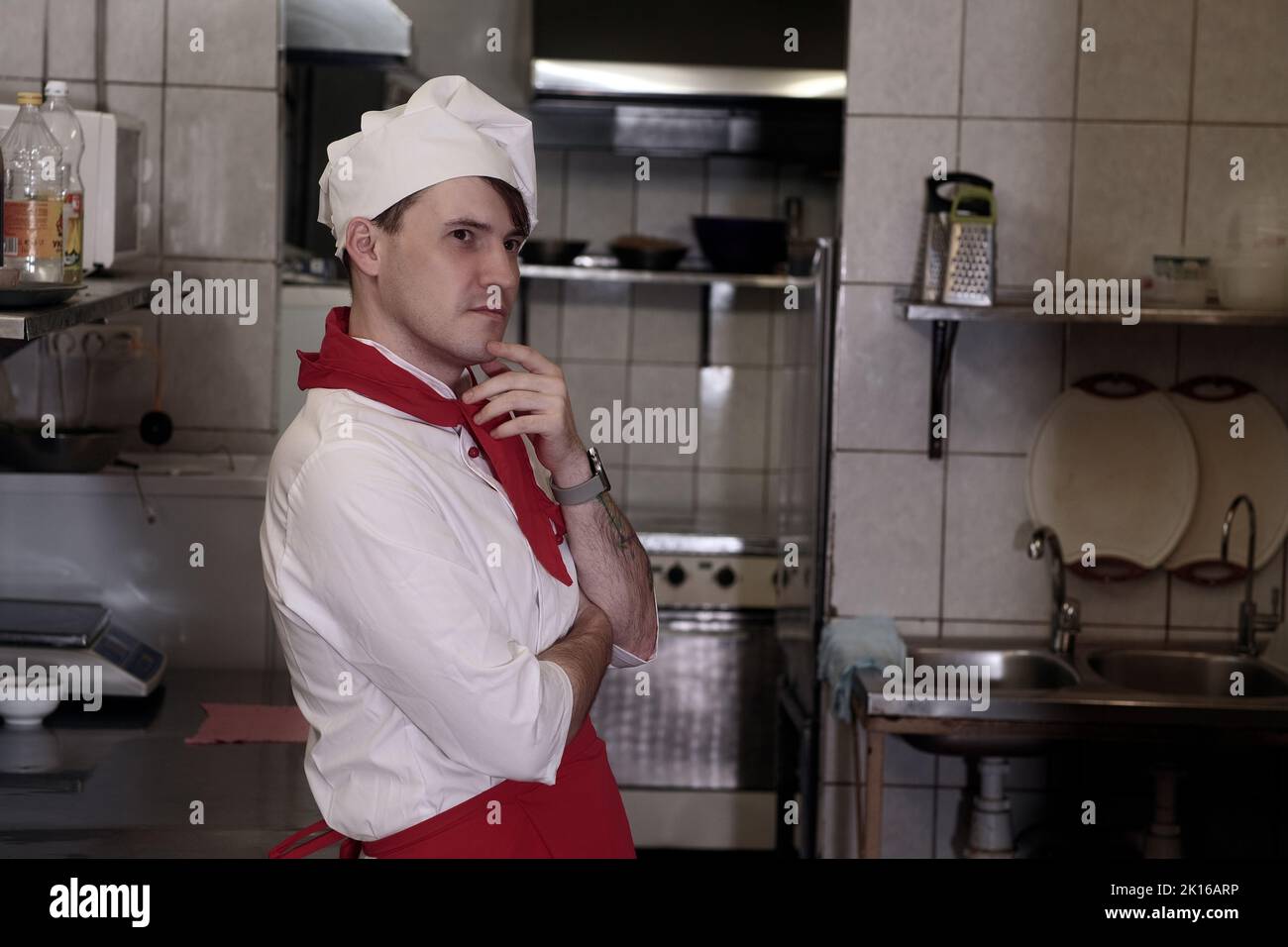 Young handsome chef posing in kitchen in restaurant. Portrait of ...