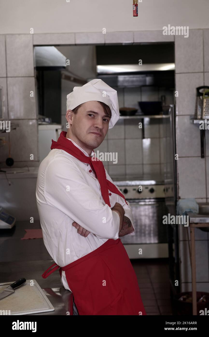 Young handsome chef posing in kitchen in restaurant. Portrait of ...